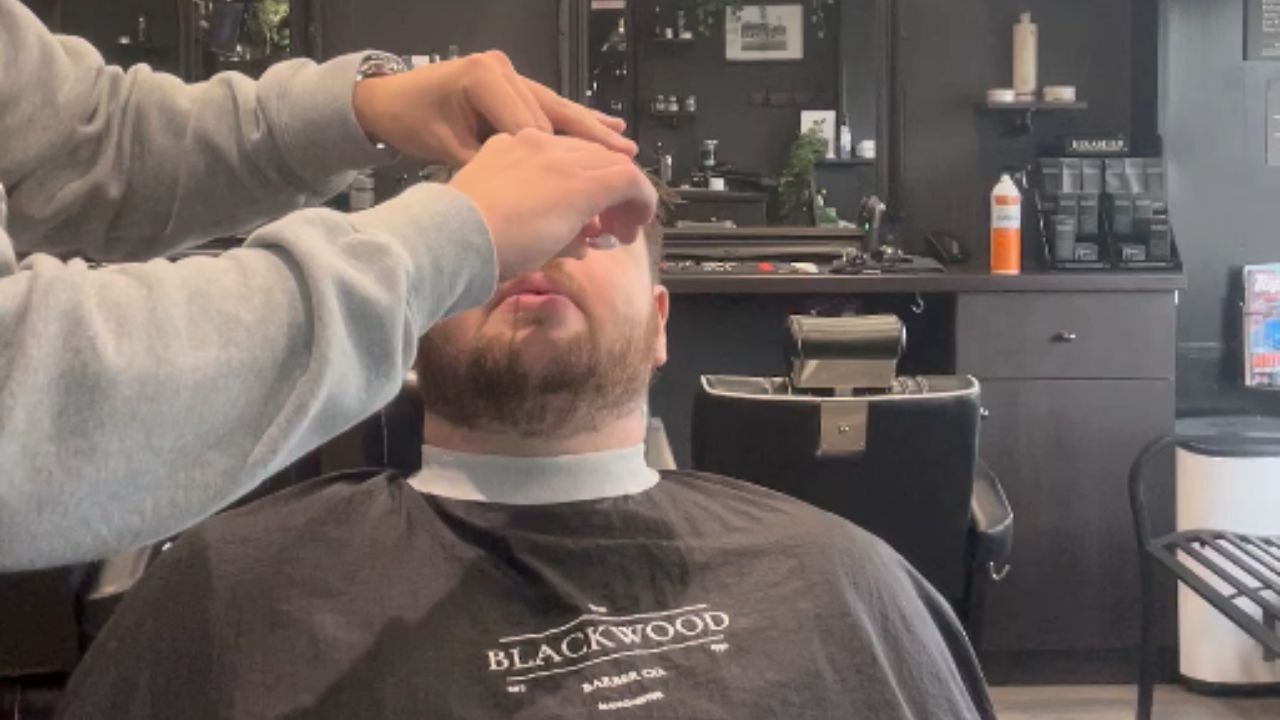 Tense moment: Barber struggles to remove nose wax strip stuck in client ...