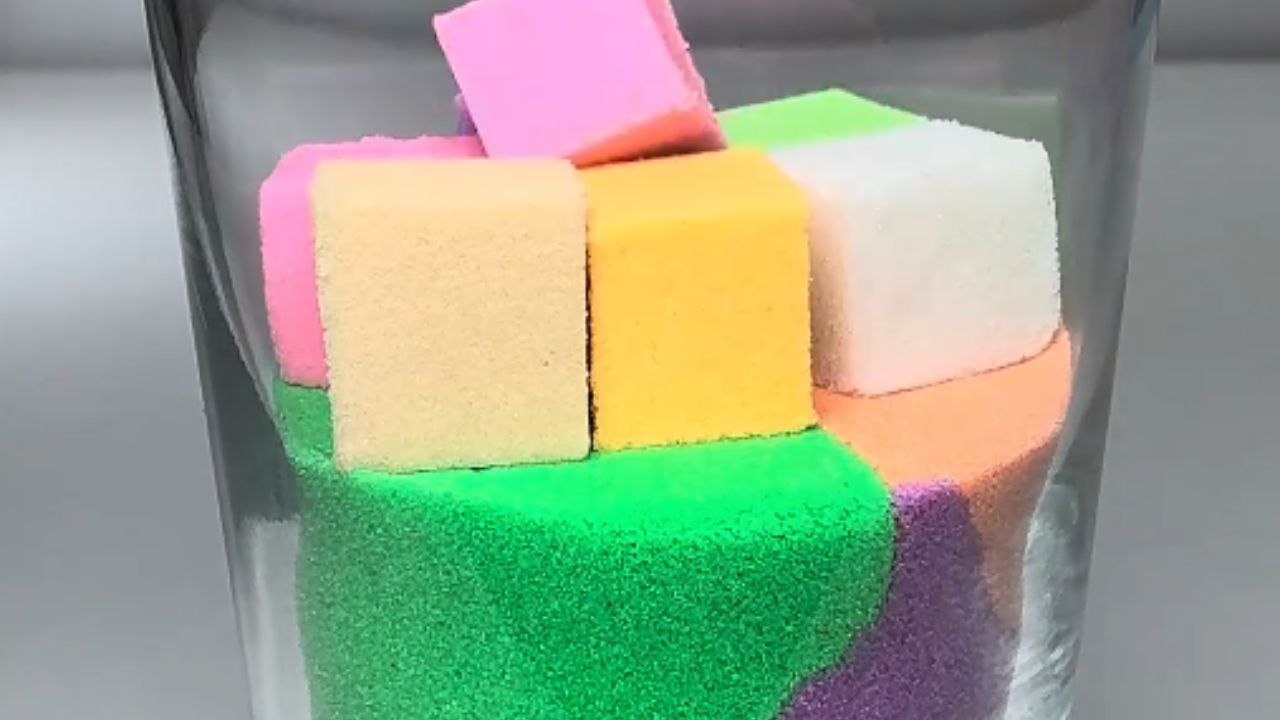 Kinetic sand blocks stacked and leveled in glass with colorful topping ...